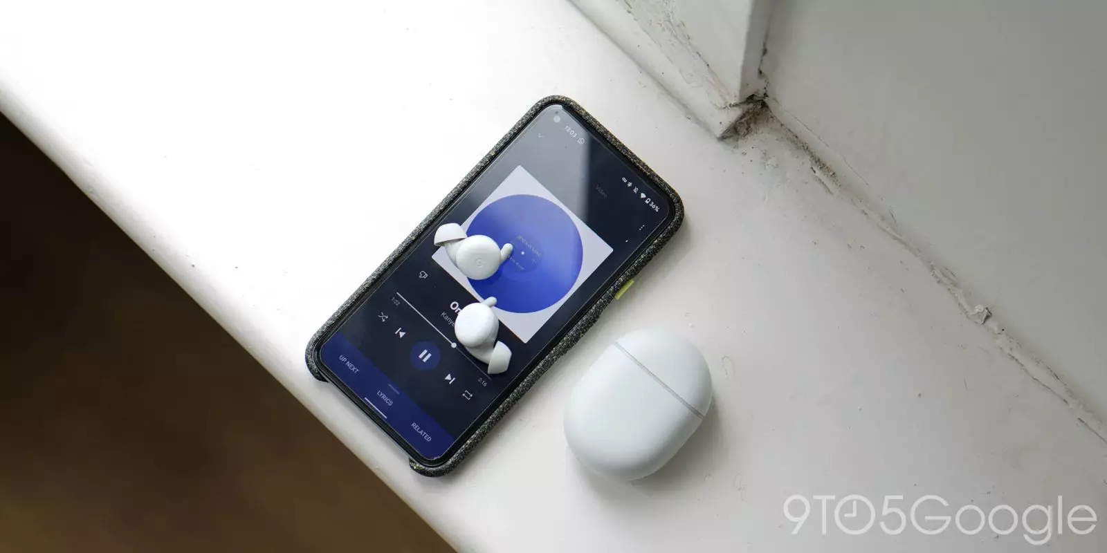 Ama-earbud ochungechunge lwe-Pixel Buds A abekwe esibukweni se-Pixel 5 esebenzisa i-YouTube Music edlala i-Kanye West